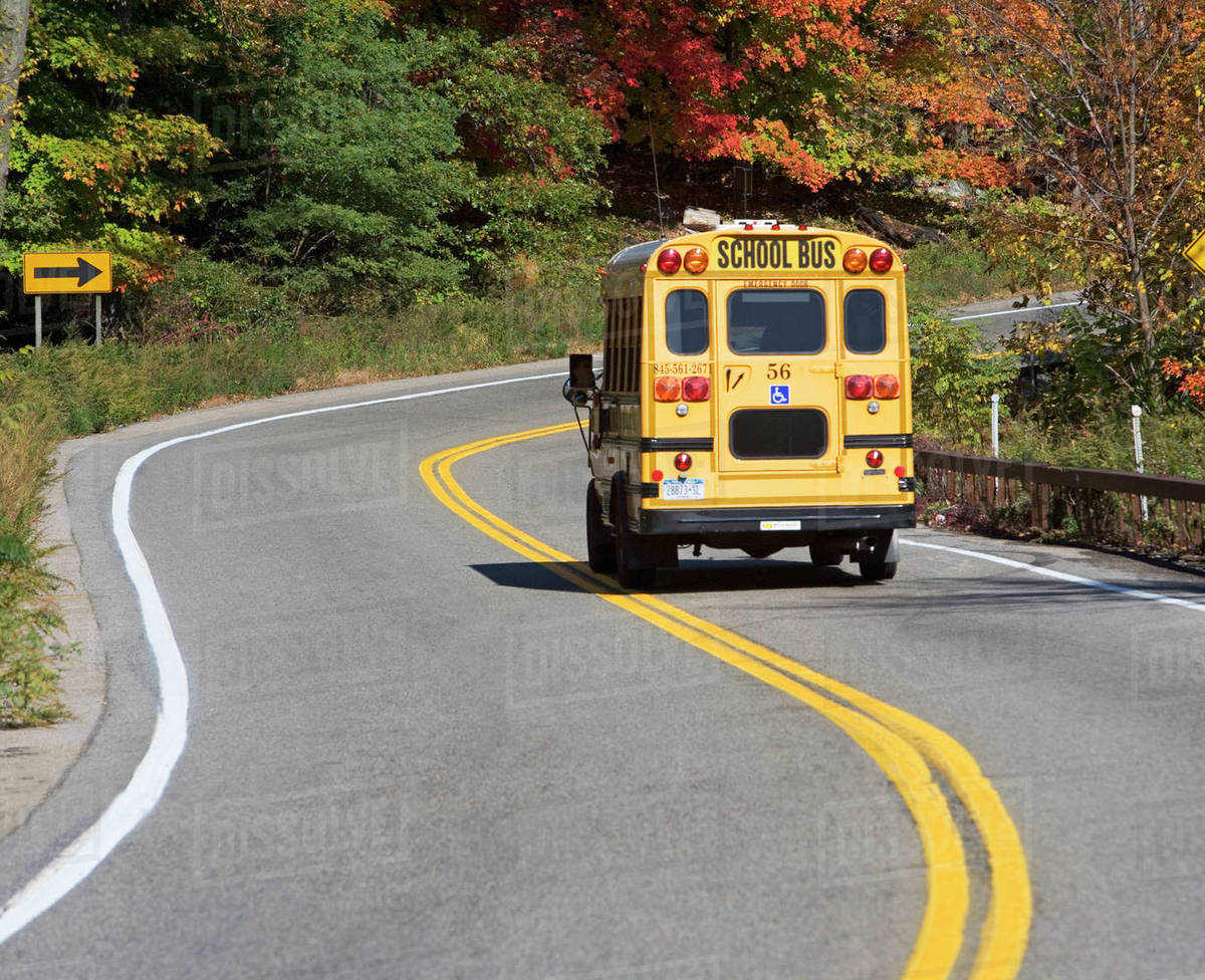 School bus driving down rural road - Royalty-free Stock Photo | Dissolve