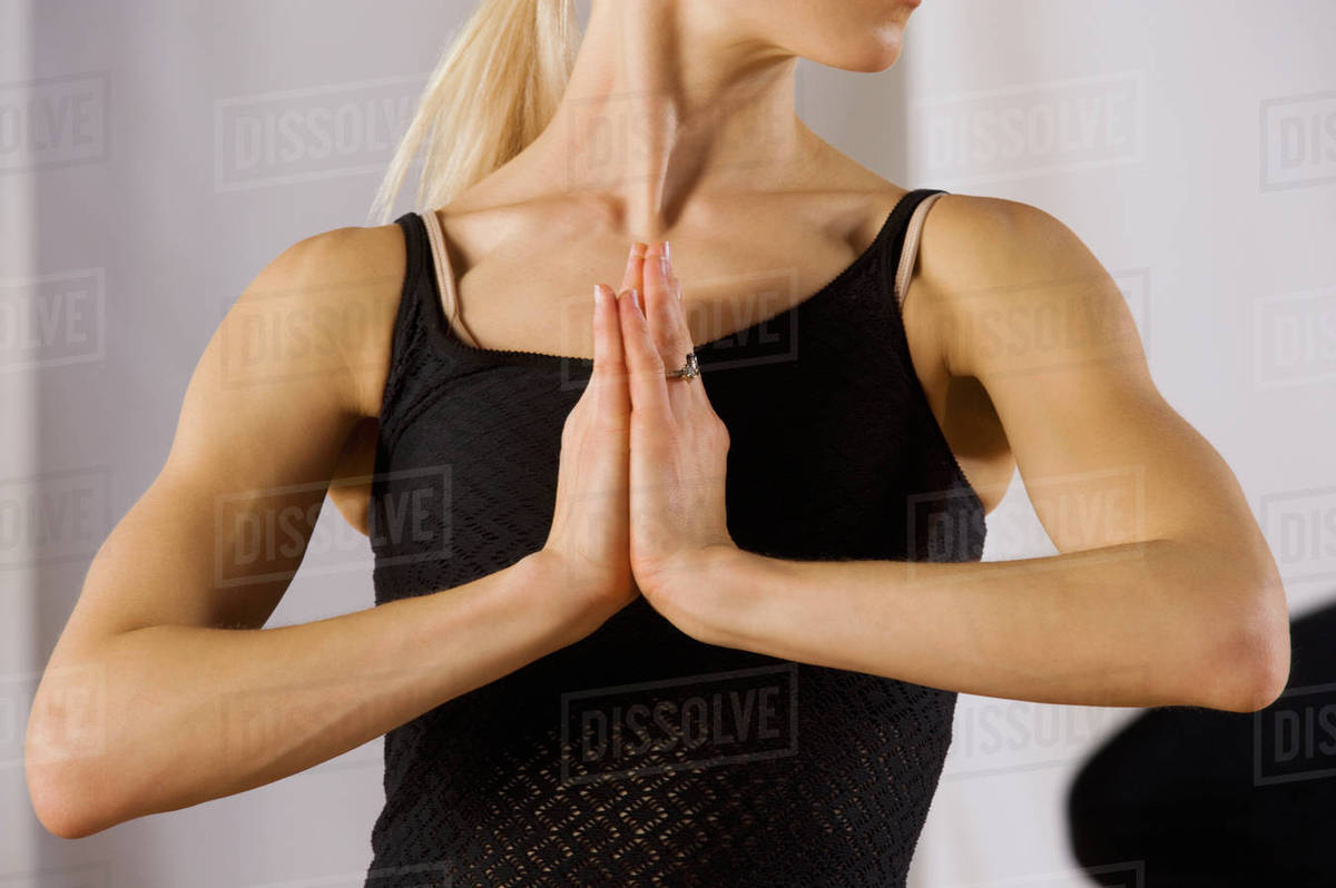 Woman with hands pressed together - Stock Photo - Dissolve