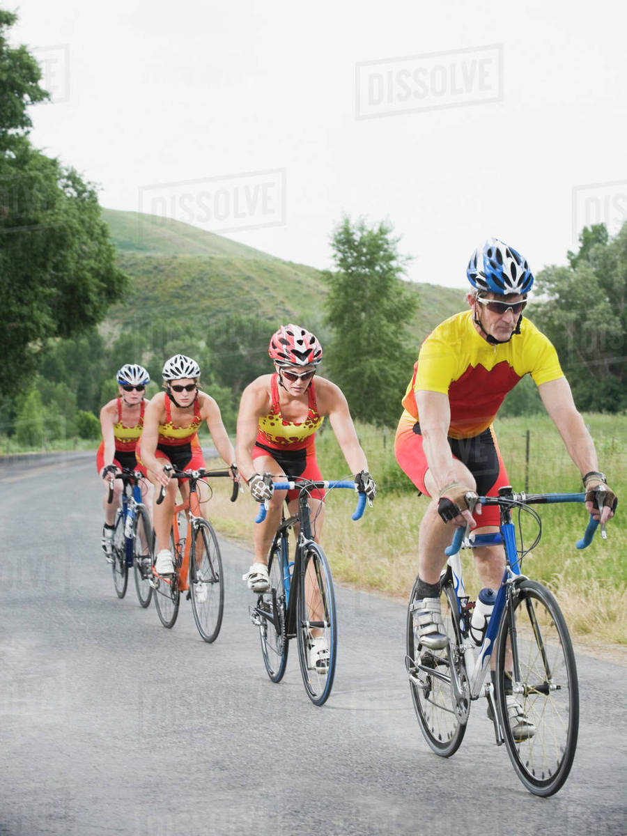 Cyclists in a row on country road - Royalty-free Stock Photo | Dissolve