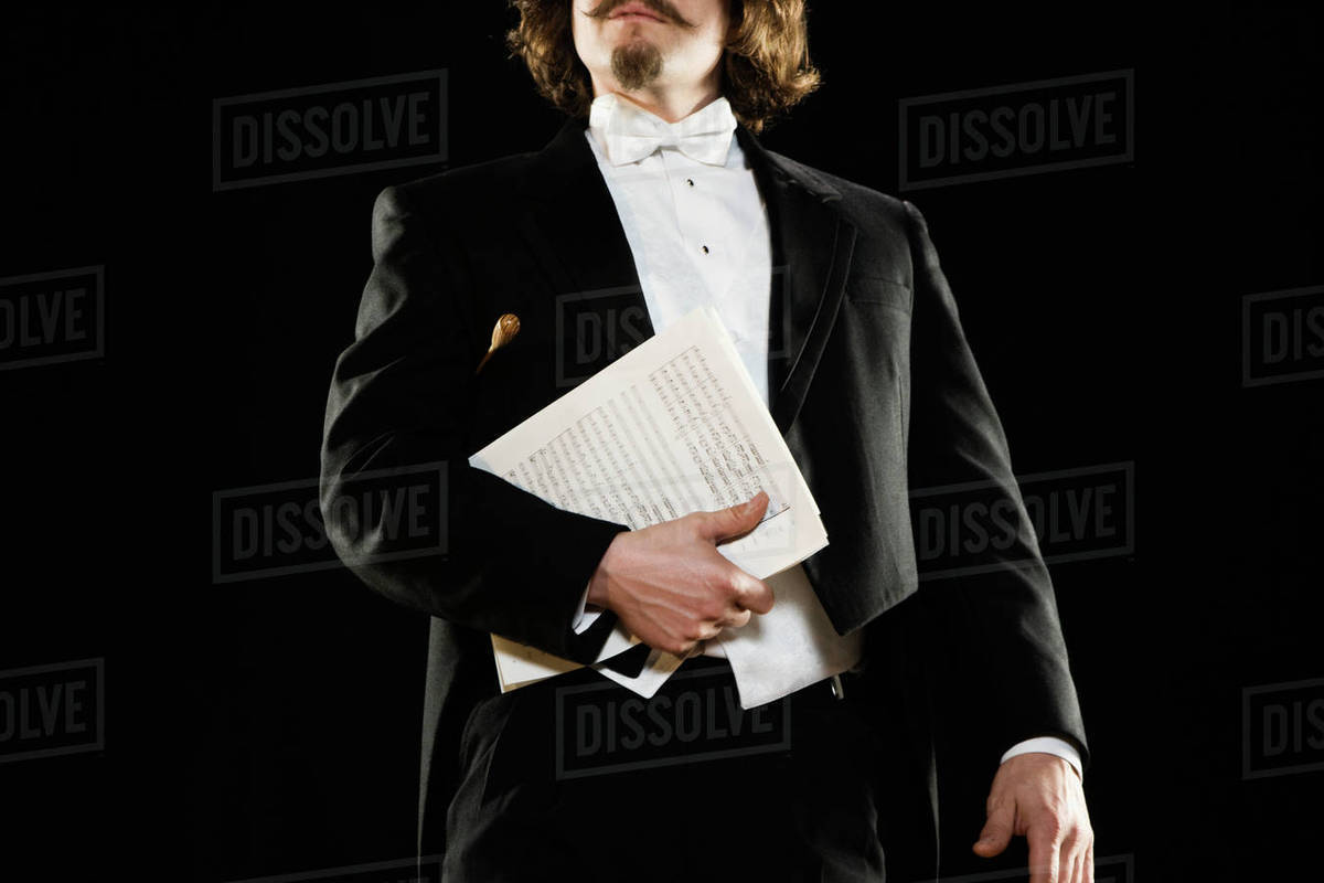 Man in tuxedo holding sheet music - Royalty-free Stock Photo | Dissolve