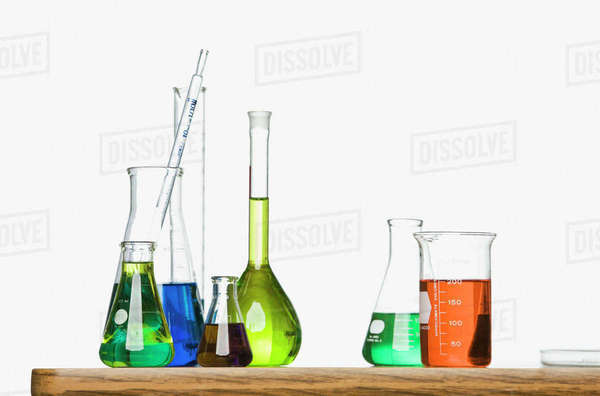 Science beakers with liquid on table - Stock Photo - Dissolve
