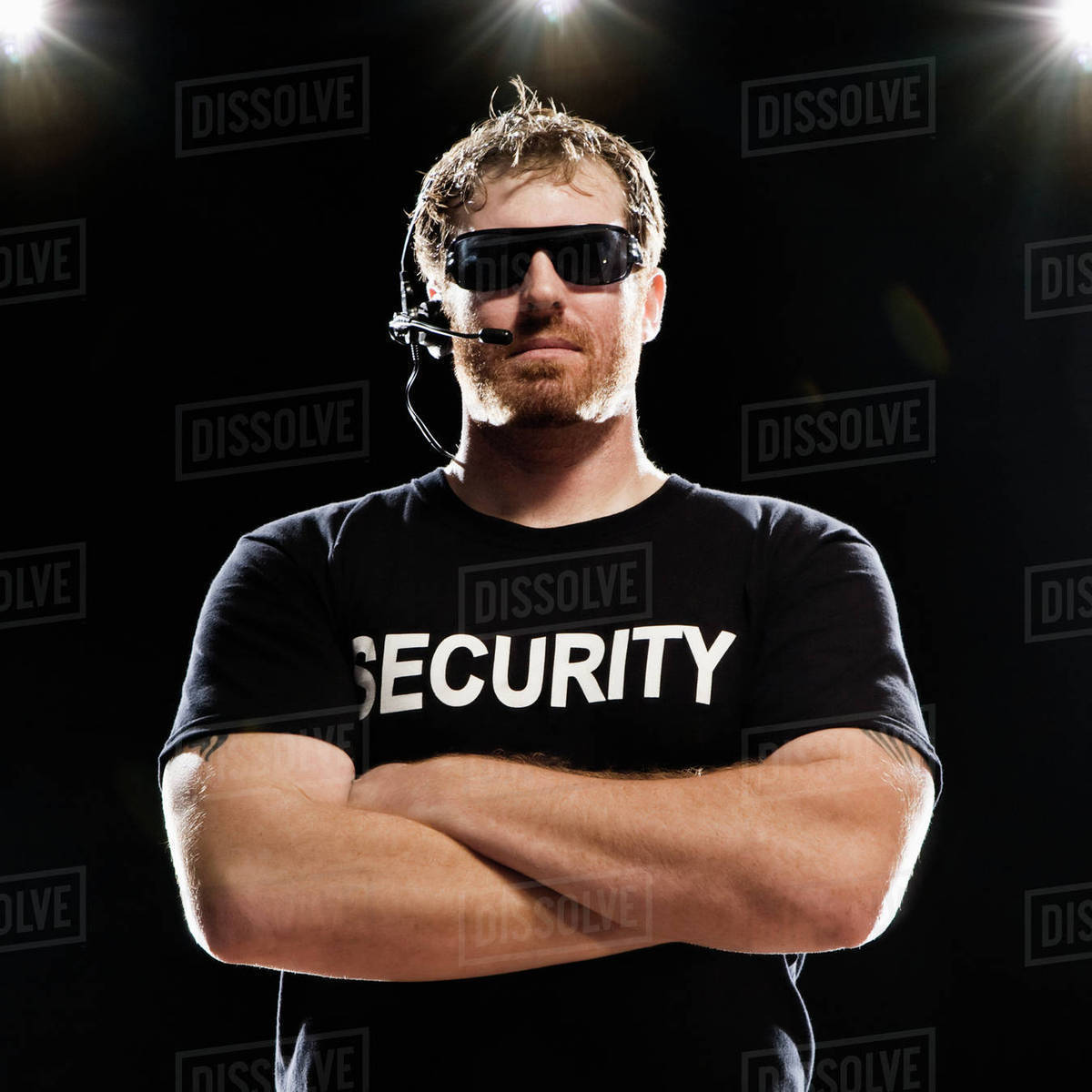 Security guard with headset posing with arms crossed - Royalty-free ...