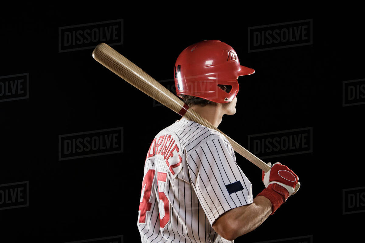 Baseball player standing with bat - Stock Photo - Dissolve