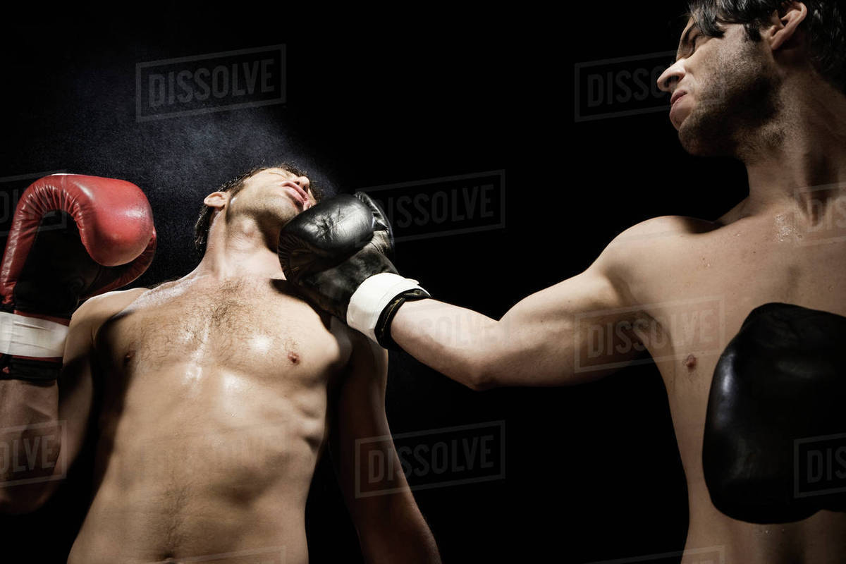 Boxer punching opponent in jaw - Royalty-free Stock Photo | Dissolve
