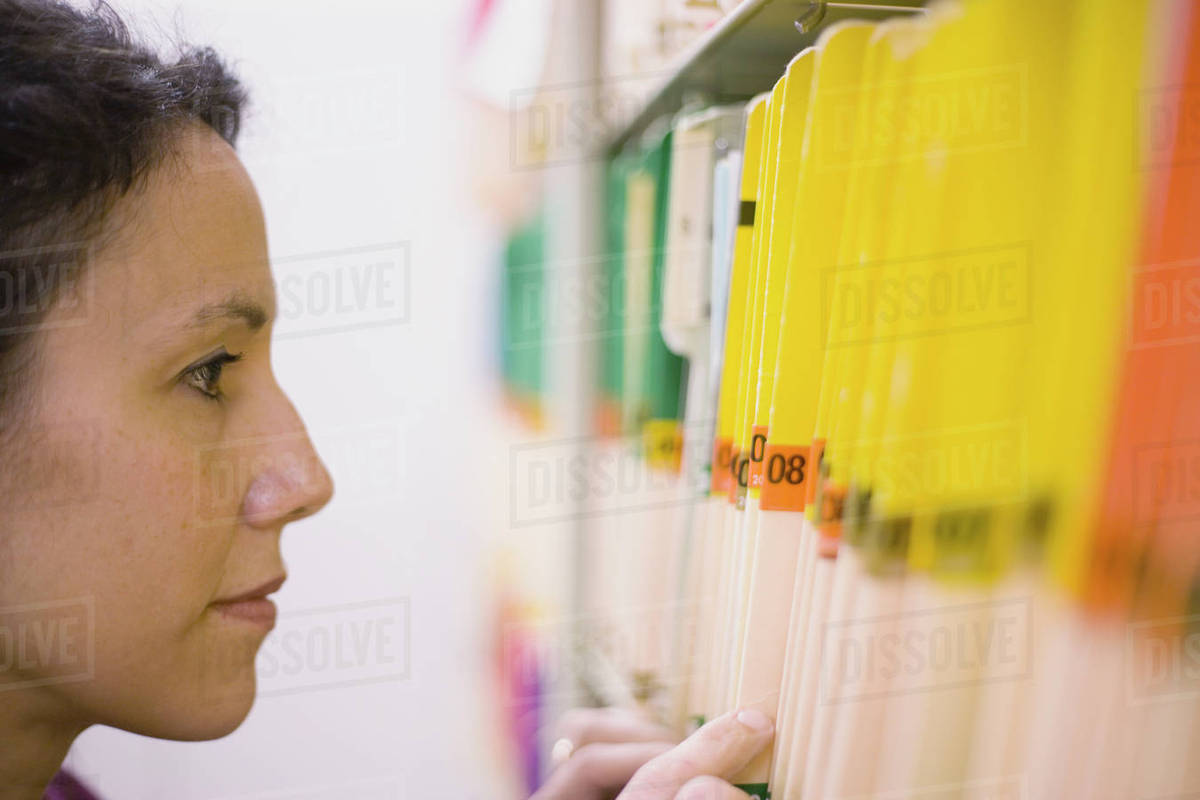 Woman looking at folders - Royalty-free Stock Photo | Dissolve