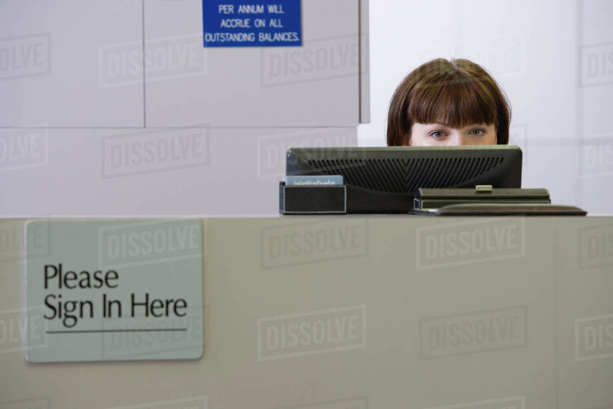 Receptionist Sitting Behind Counter - Royalty-free Stock Photo | Dissolve