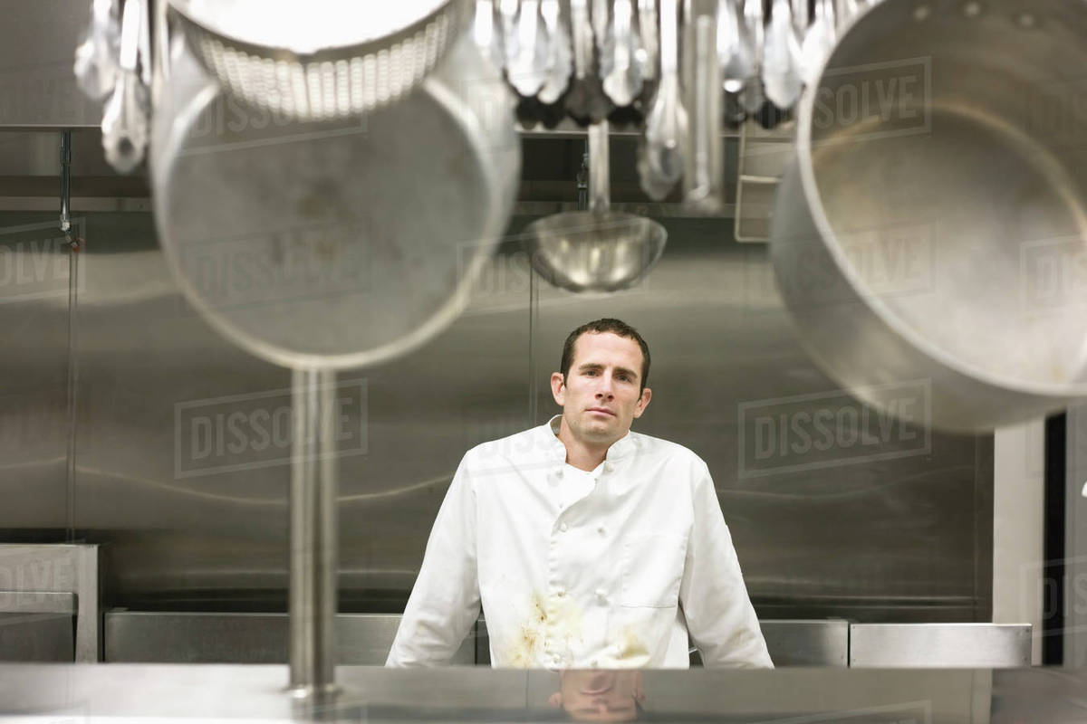 Dirty chef leaning against stove - Royalty-free Stock Photo | Dissolve