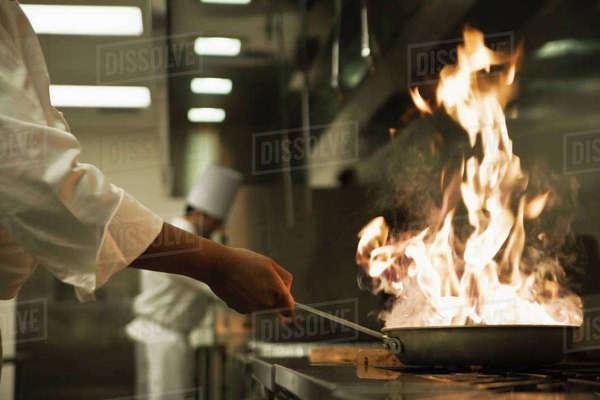 Chef holding flaming pan - Royalty-free Stock Photo | Dissolve