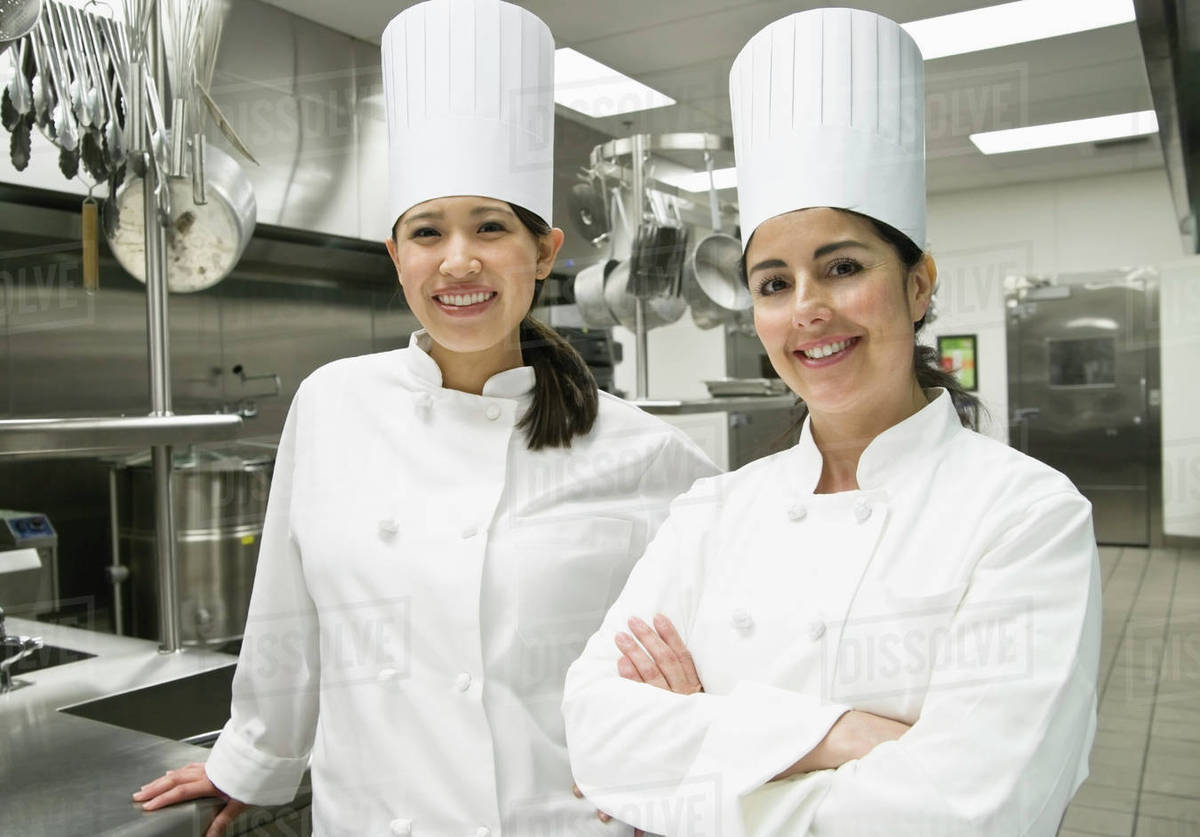 Female chefs posing in kitchen - Royalty-free Stock Photo | Dissolve