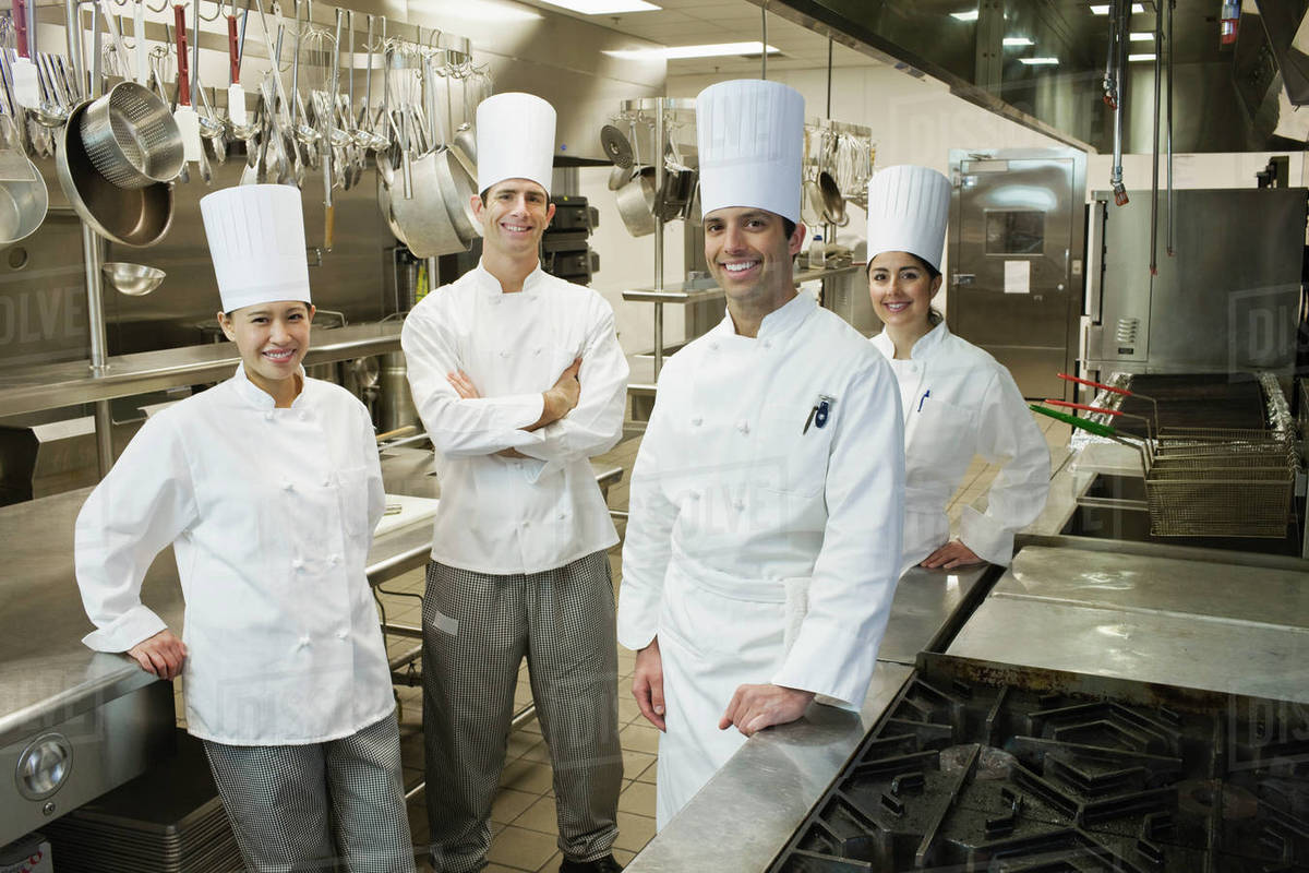 Chefs posing in kitchen - Royalty-free Stock Photo | Dissolve
