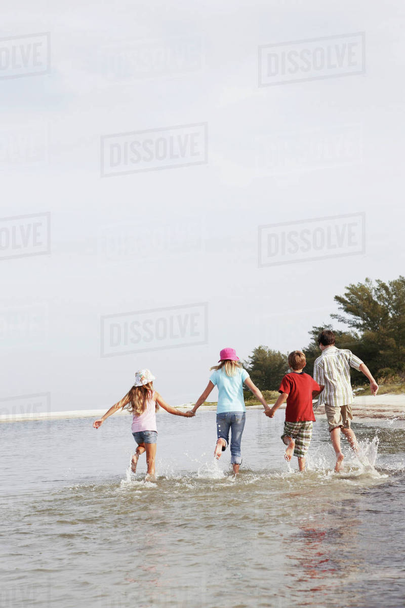Children running in ocean - Stock Photo - Dissolve