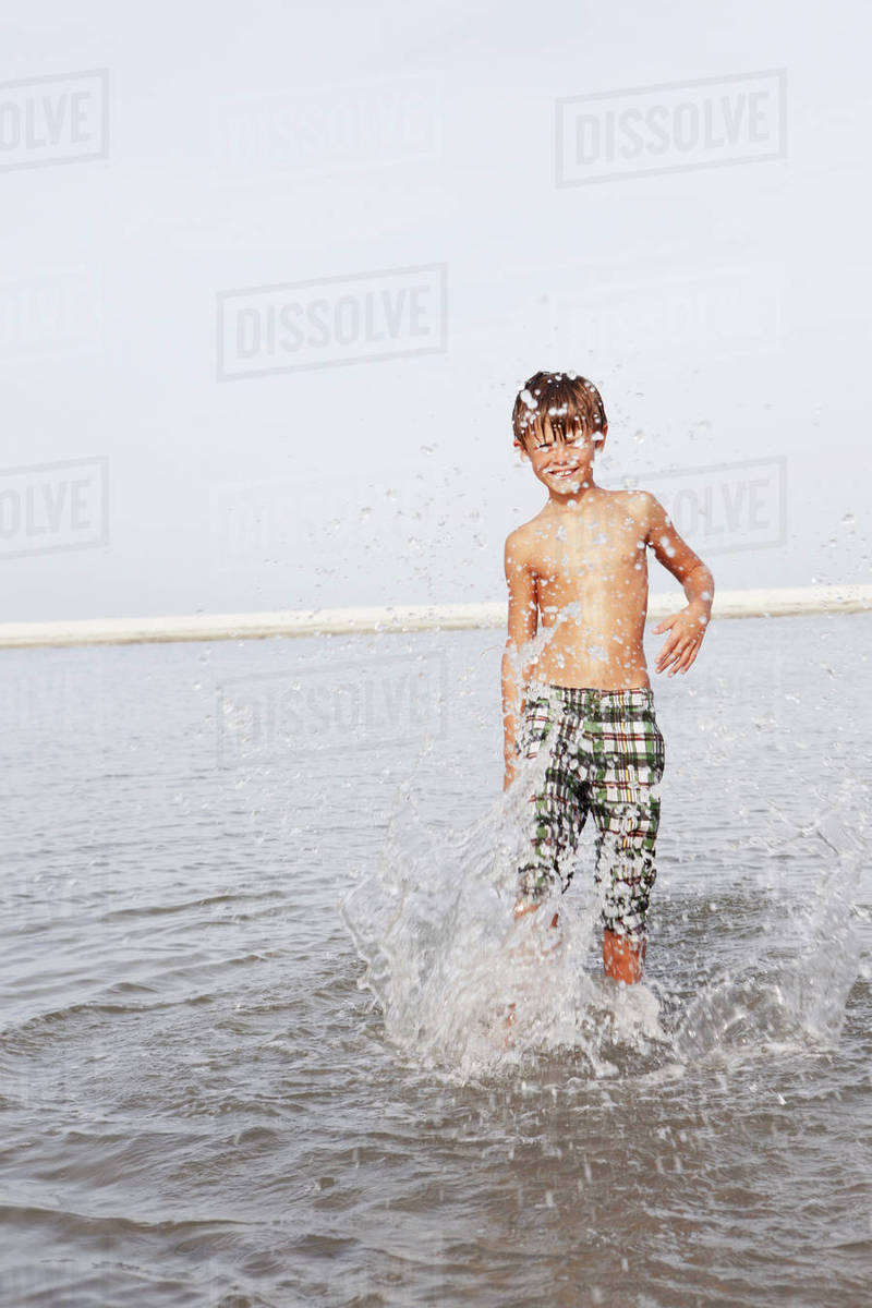 Boy splashing in ocean - Royalty-free Stock Photo | Dissolve