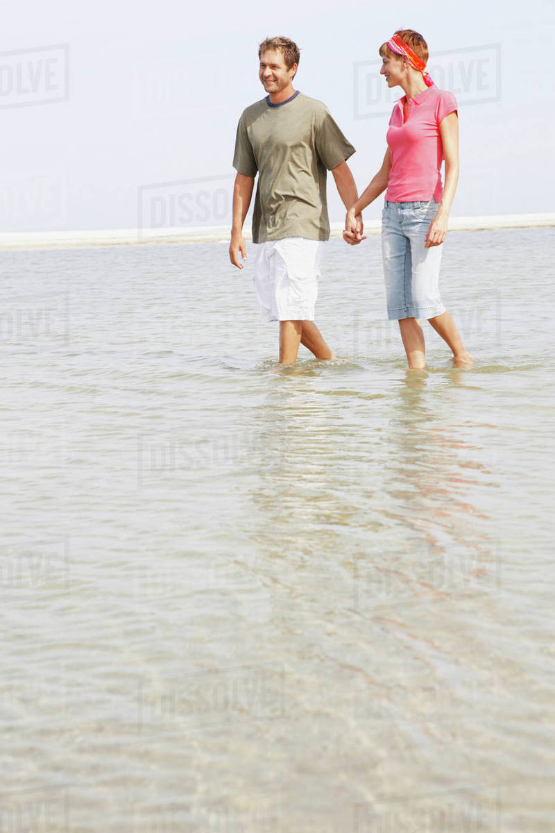 Couple wading in ocean - Royalty-free Stock Photo | Dissolve