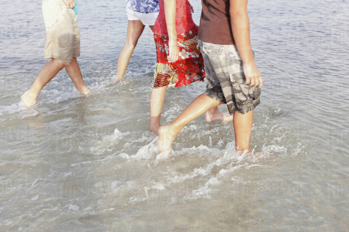 Friends wading in ocean - Royalty-free Stock Photo | Dissolve
