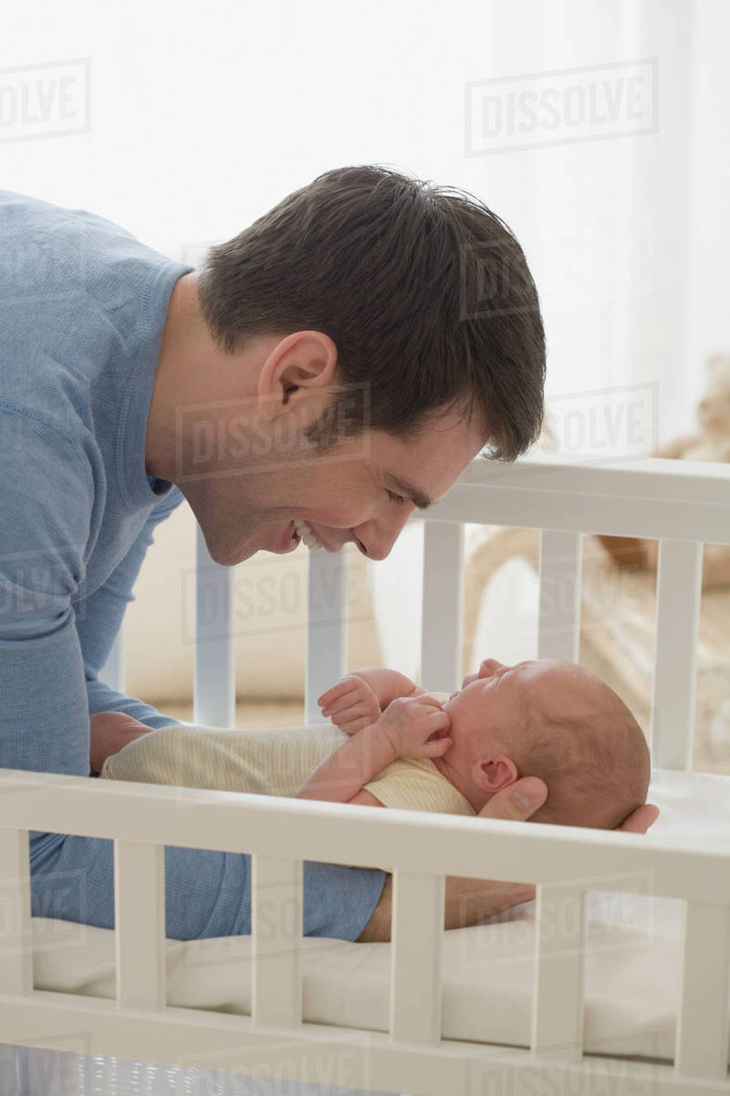 Father smiling at newborn baby - Stock Photo - Dissolve