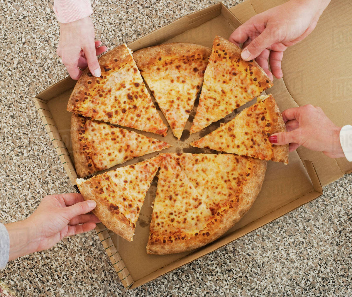 People talking slices of pizza from box - Stock Photo - Dissolve