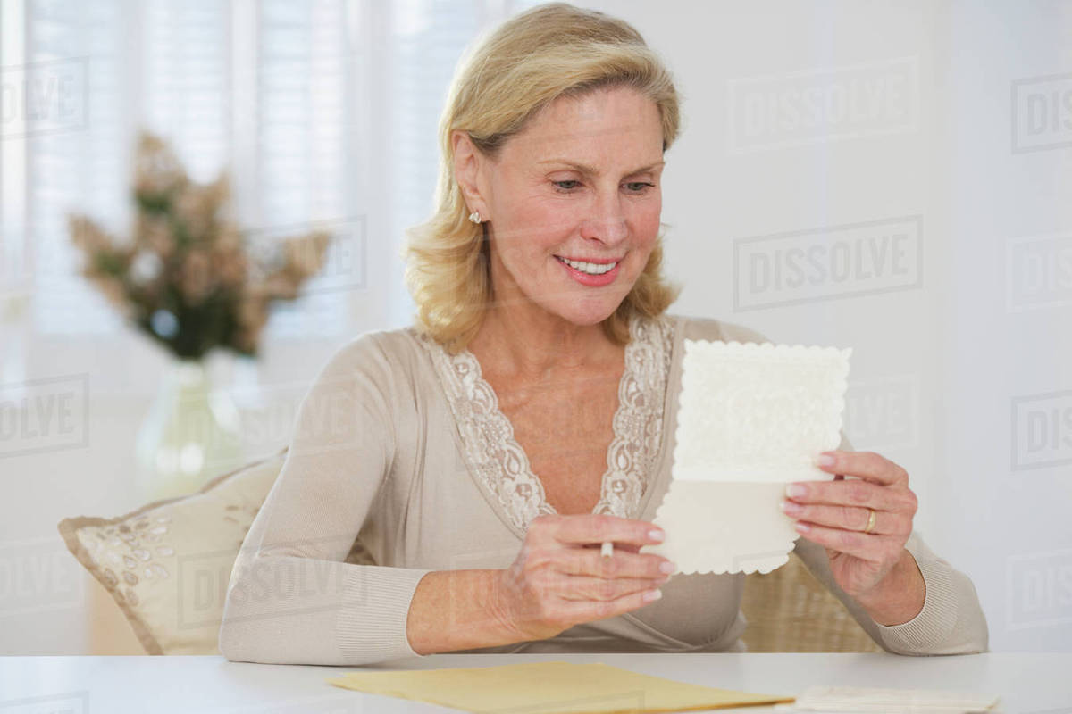 Senior woman reading card - Royalty-free Stock Photo | Dissolve