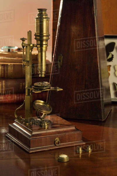 Old fashioned microscope on table - Stock Photo - Dissolve