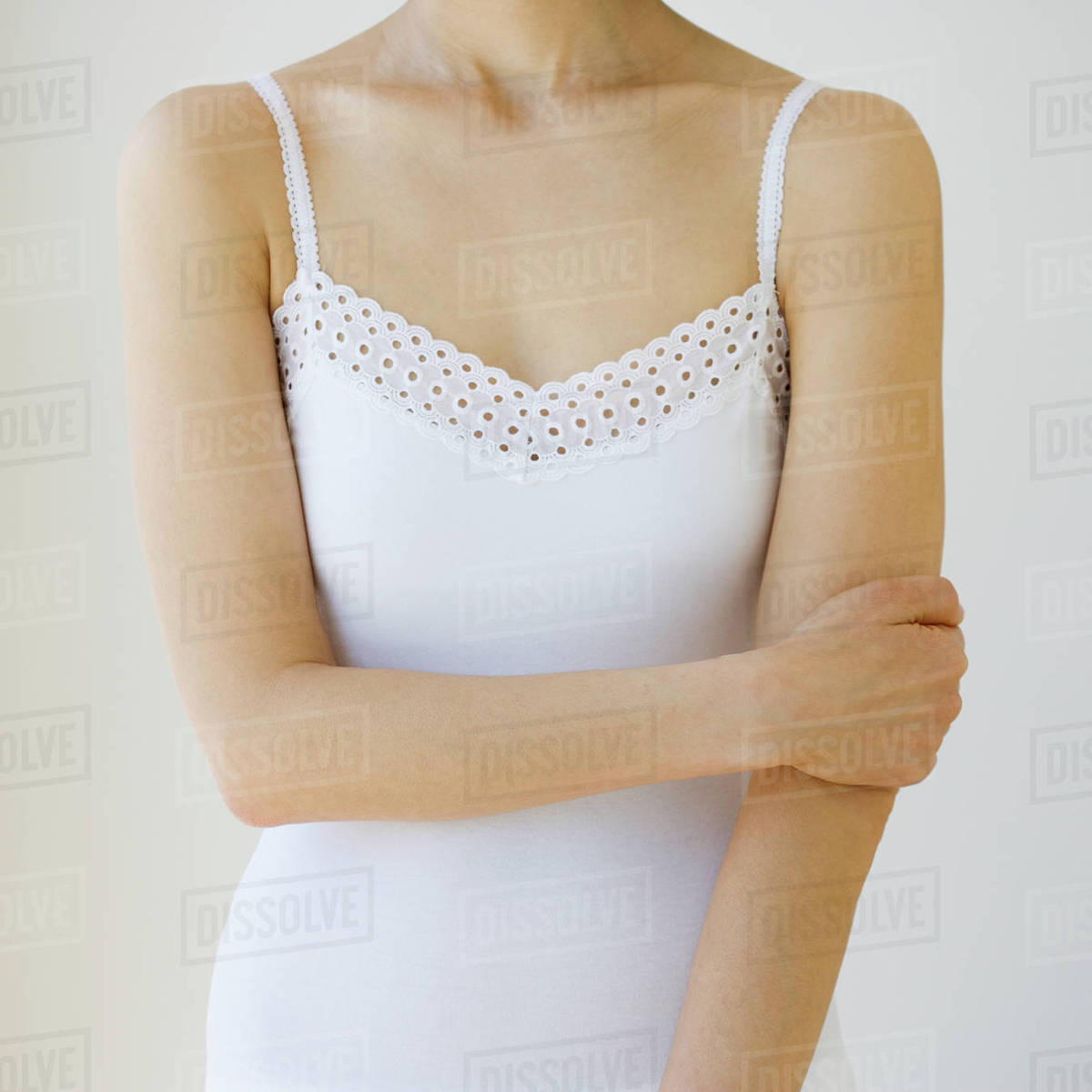 Woman with arm crossed over torso - Stock Photo - Dissolve