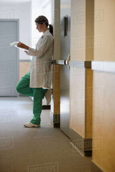 Female doctor reading chart - Stock Photo - Dissolve