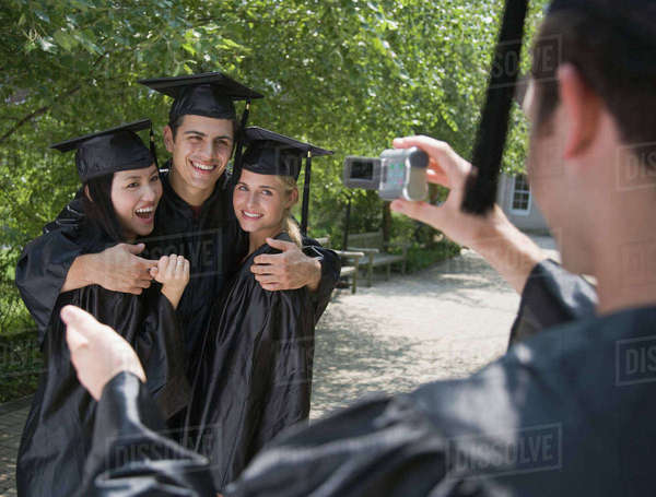 Group of college graduates having photograph taken - Stock Photo - Dissolve