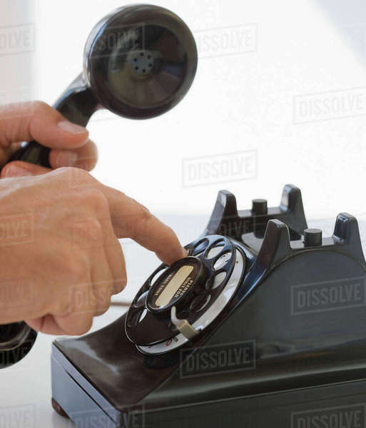 Man dialing rotary telephone - Stock Photo - Dissolve