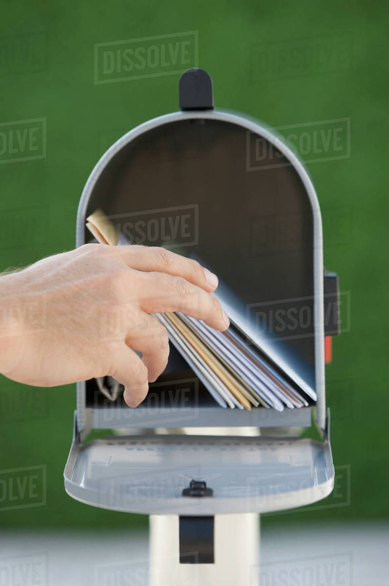 Man taking mail out of mailbox - Royalty-free Stock Photo | Dissolve