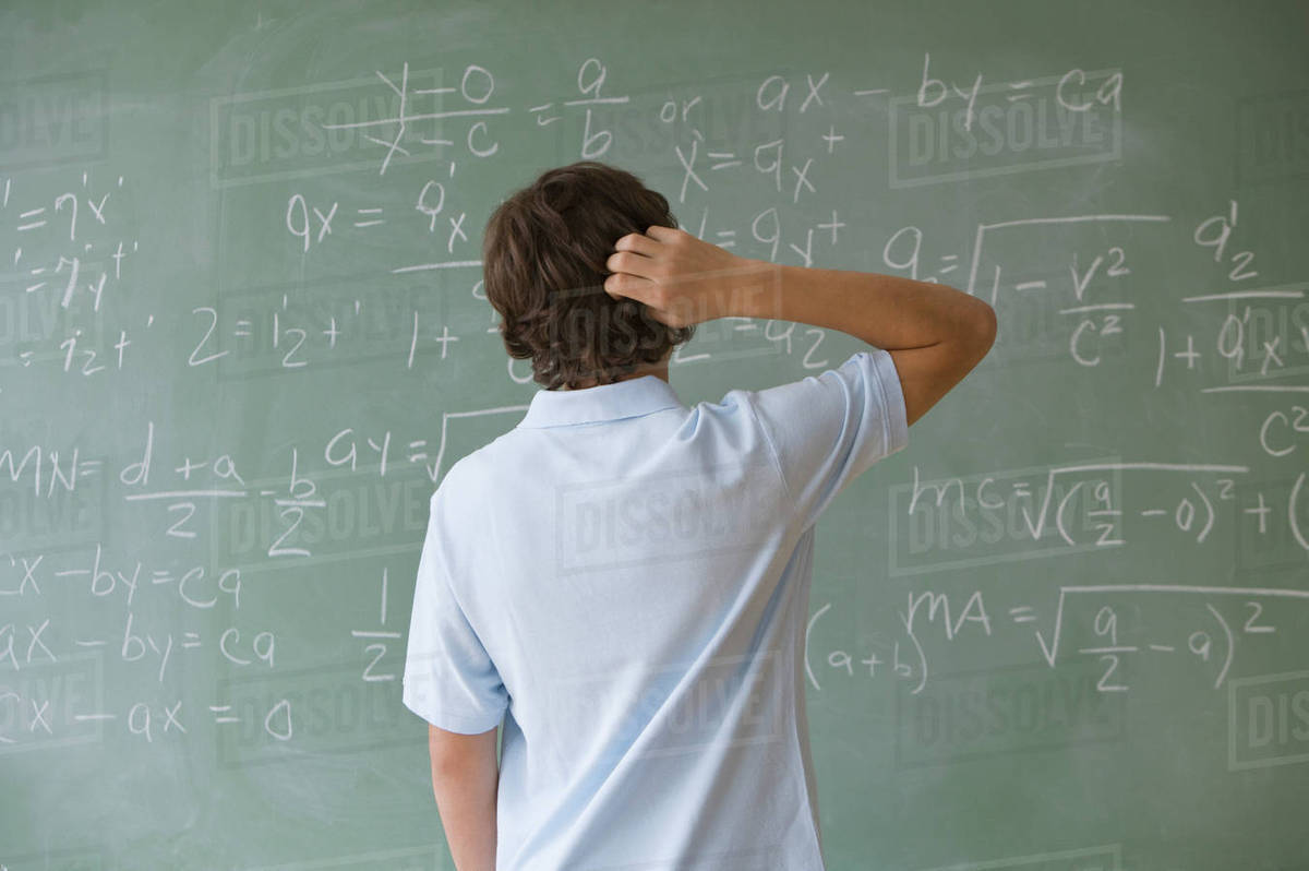 Teenaged boy looking at math equations on blackboard - Stock Photo ...