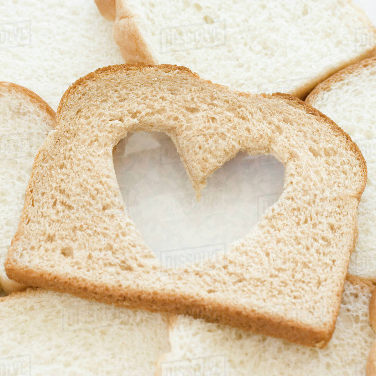 Slice of bread with heart in middle - Stock Photo - Dissolve