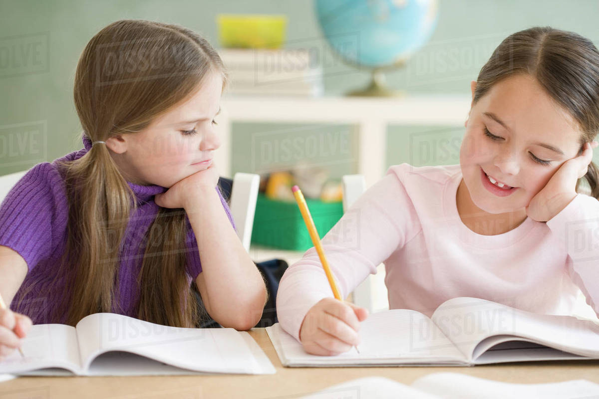 Two girls studying in classroom - Royalty-free Stock Photo | Dissolve