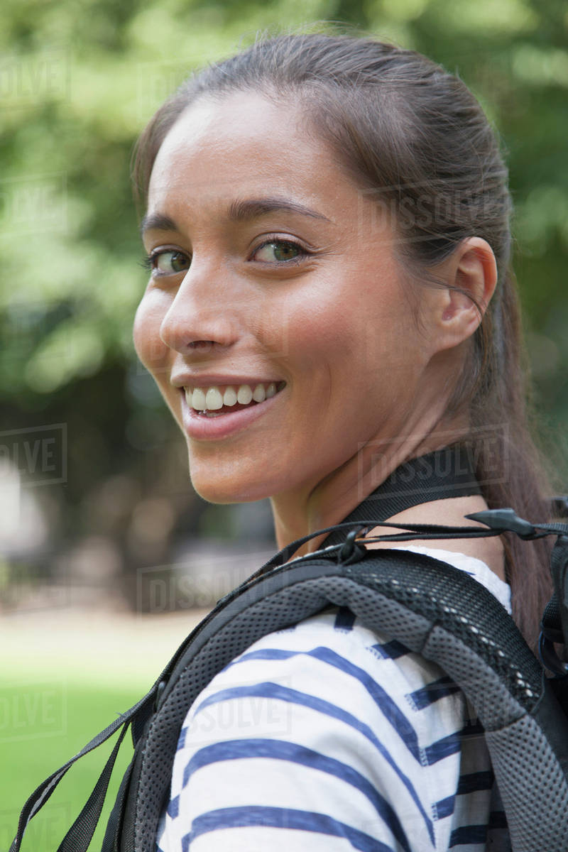 Portrait of young woman with backpack - Stock Photo - Dissolve