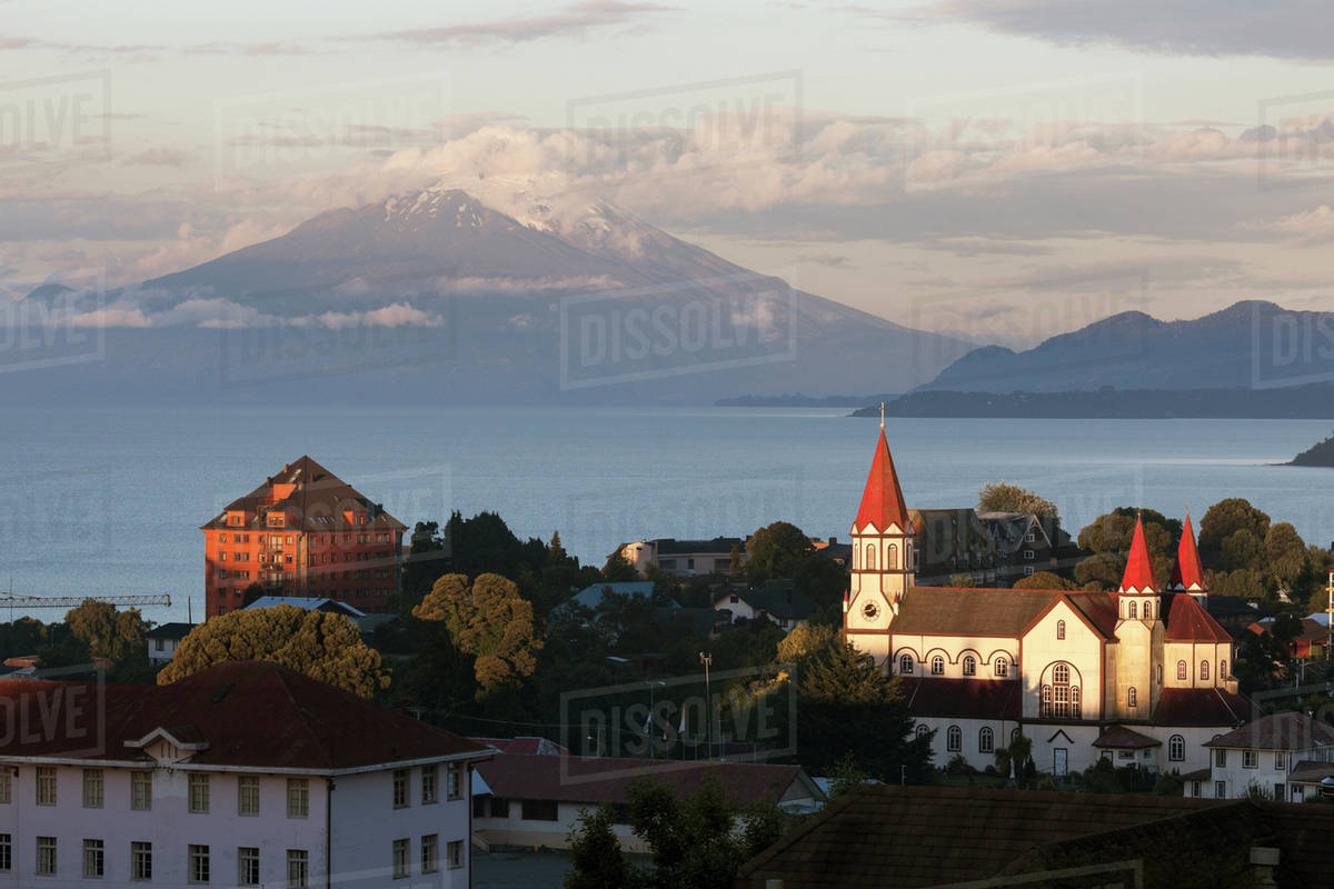 Town skyline with volcano in background - Stock Photo - Dissolve