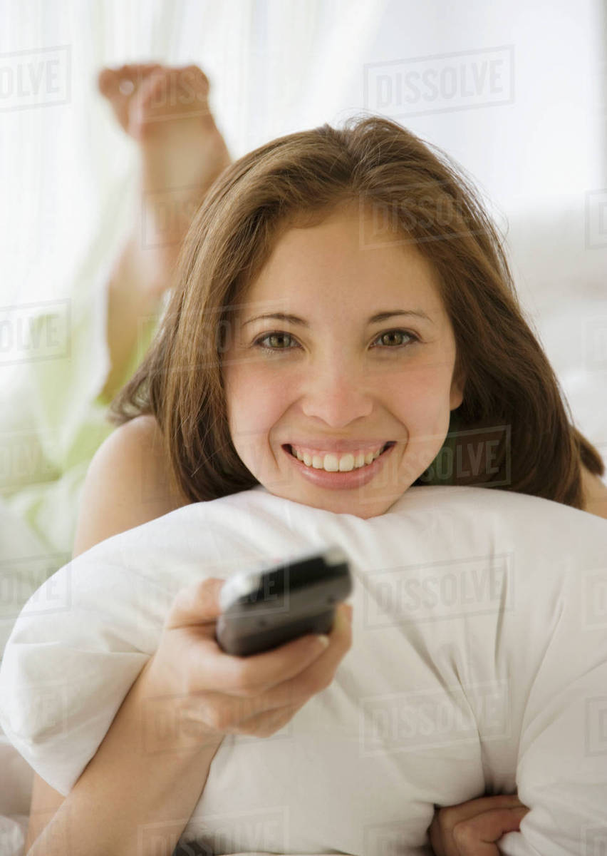 Woman pointing remote control - Royalty-free Stock Photo | Dissolve