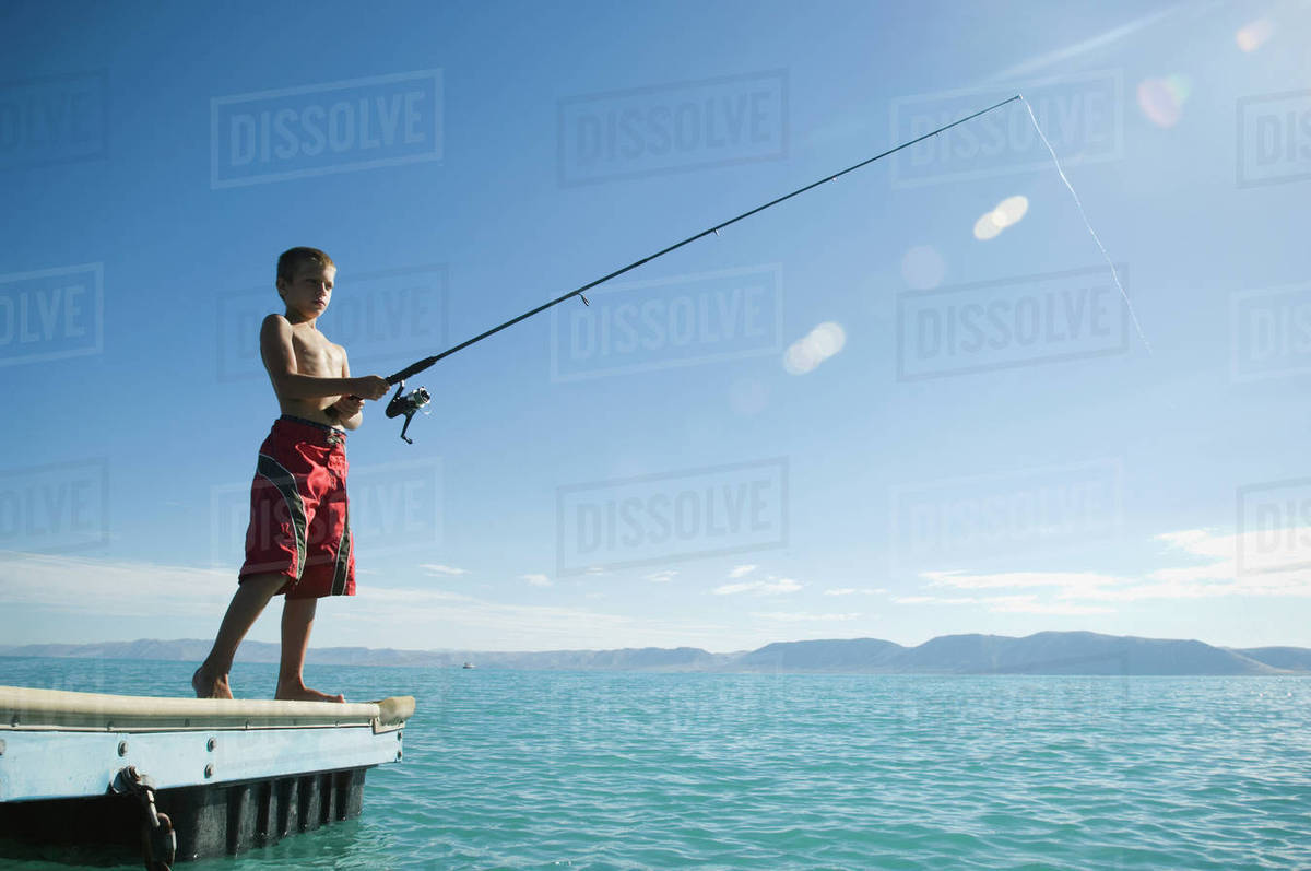 Boy fishing off dock in lake, Utah, United States - Royalty-free Stock ...