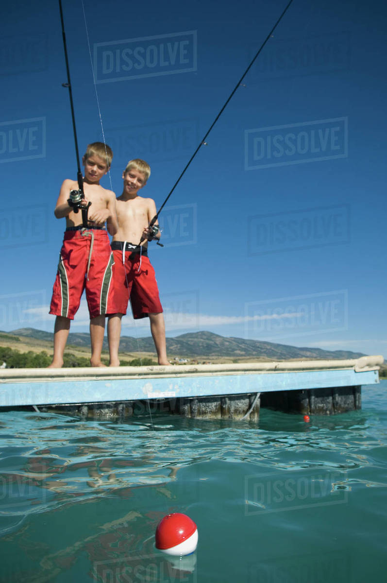 Brothers fishing off dock in lake, Utah, United States - Stock Photo ...