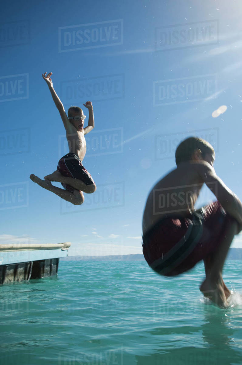 Brothers jumping off dock into lake, Utah, United States - Royalty-free ...