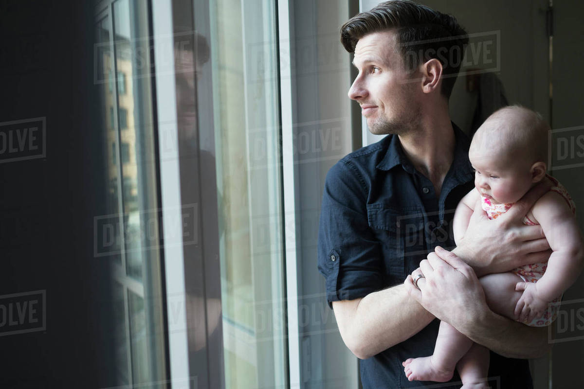 Father looking through window with daughter (2-5 months) - Royalty-free ...