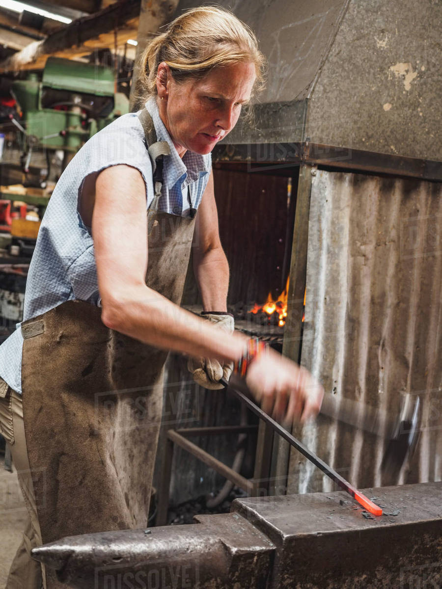 Female blacksmith working in workshop - Royalty-free Stock Photo | Dissolve