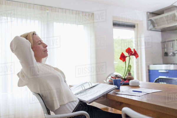Woman taking break from paperwork - Stock Photo - Dissolve
