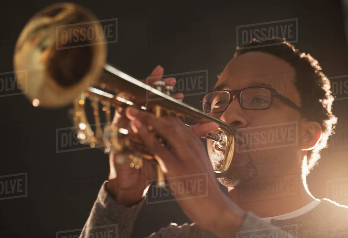 Mid adult man playing trumpet - Royalty-free Stock Photo | Dissolve