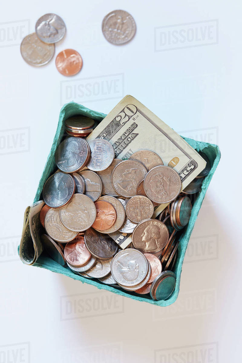 Coins and banknotes in carton box on white surface - Royalty-free Stock ...