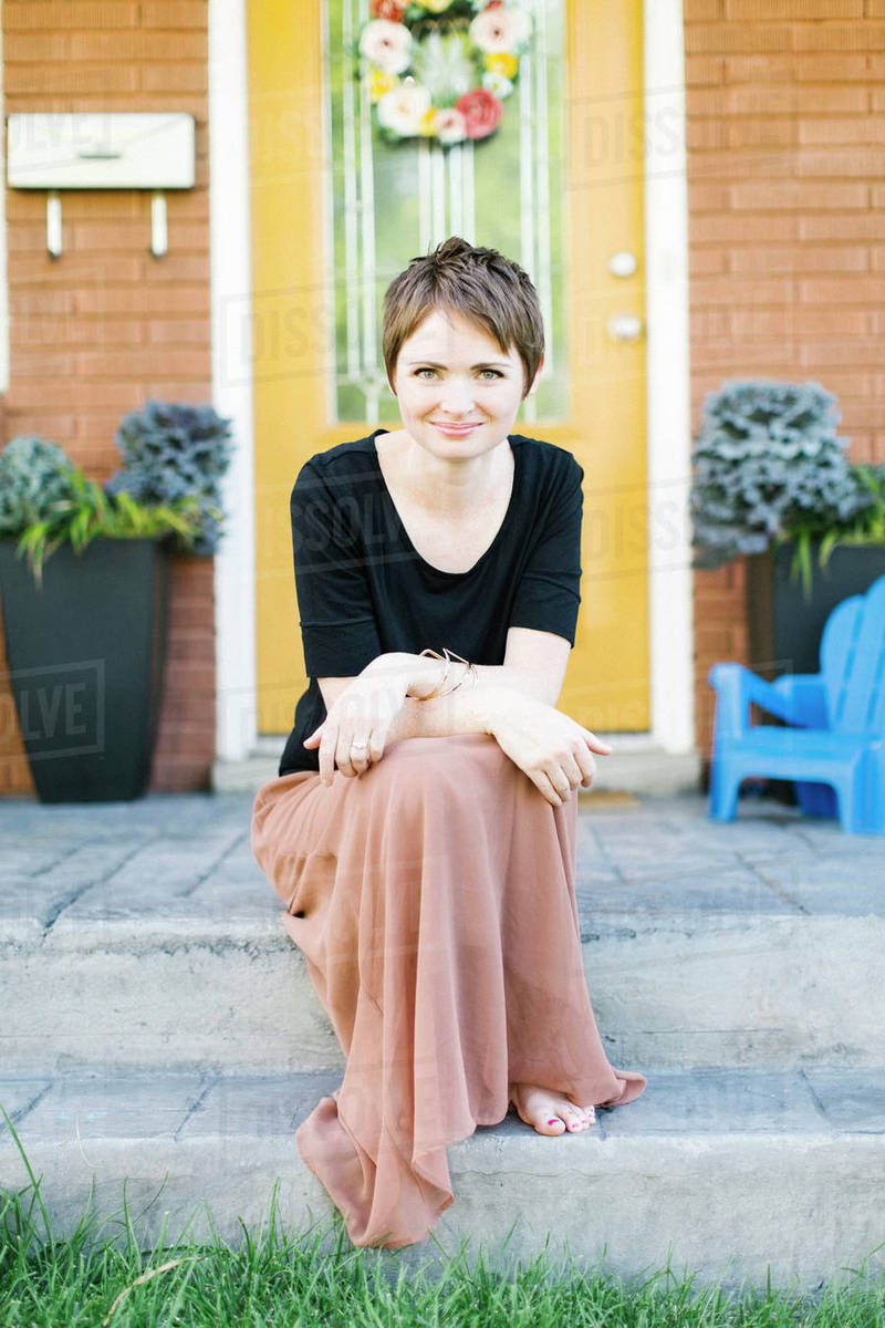 Portrait of woman sitting on step - Stock Photo - Dissolve