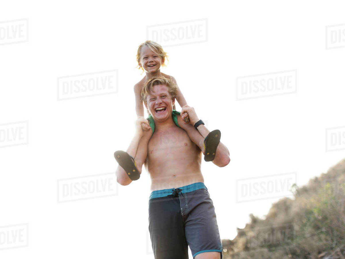Young man carrying brother on shoulders - Stock Photo - Dissolve