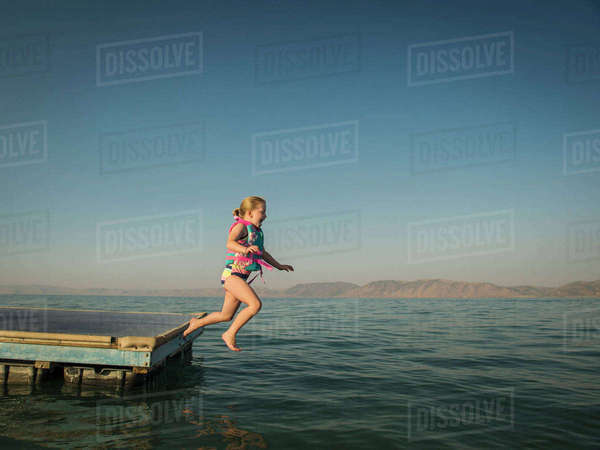Girl (4-5) jumping into lake from pier - Royalty-free Stock Photo ...