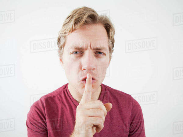 Studio Shot of mid adult man with finger on lips - Royalty-free Stock ...