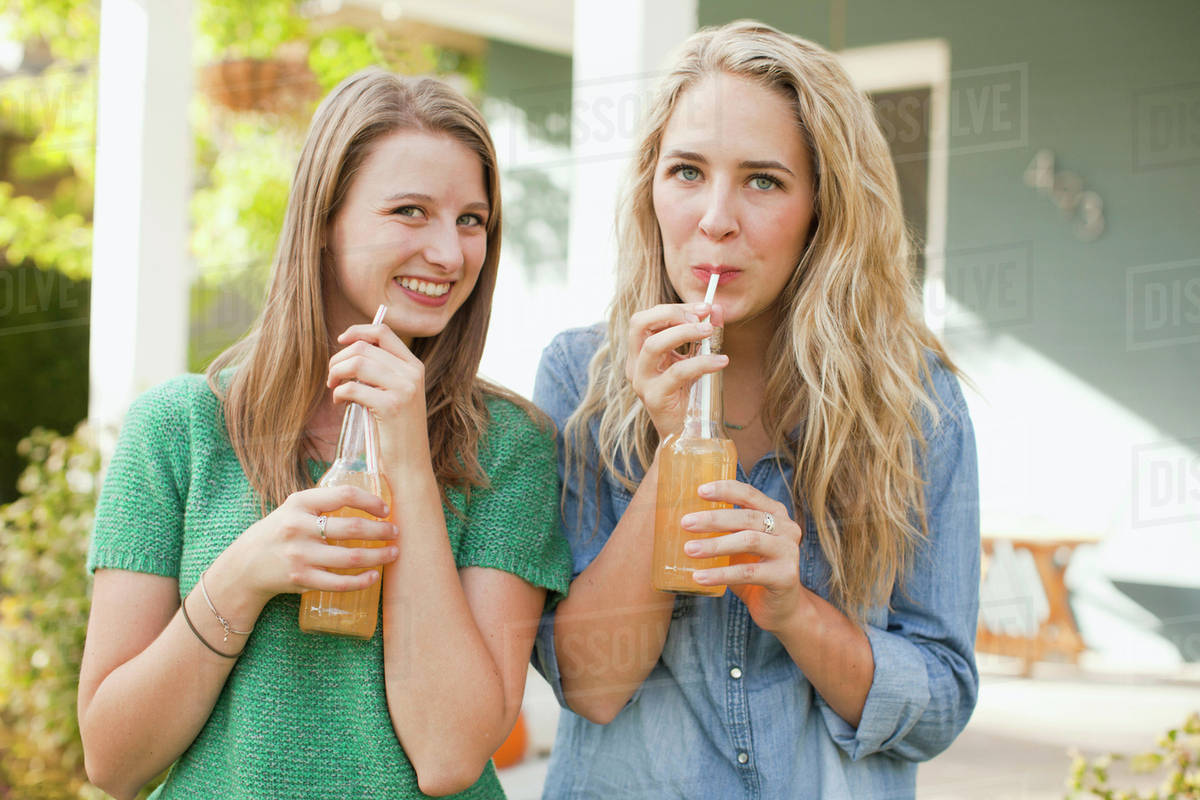 Portrait of two friends drinking soda through straw - Royalty-free ...