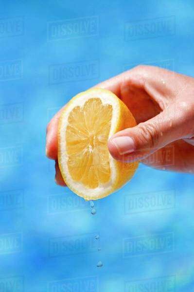 A hand squeezing a lemon - Royalty-free Stock Photo | Dissolve