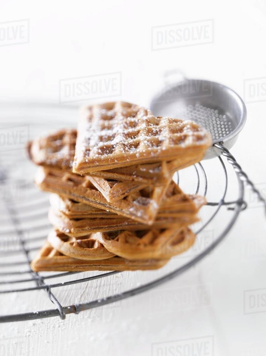 Heart-shaped waffles dusted with icing sugar on a wire rack - Stock ...