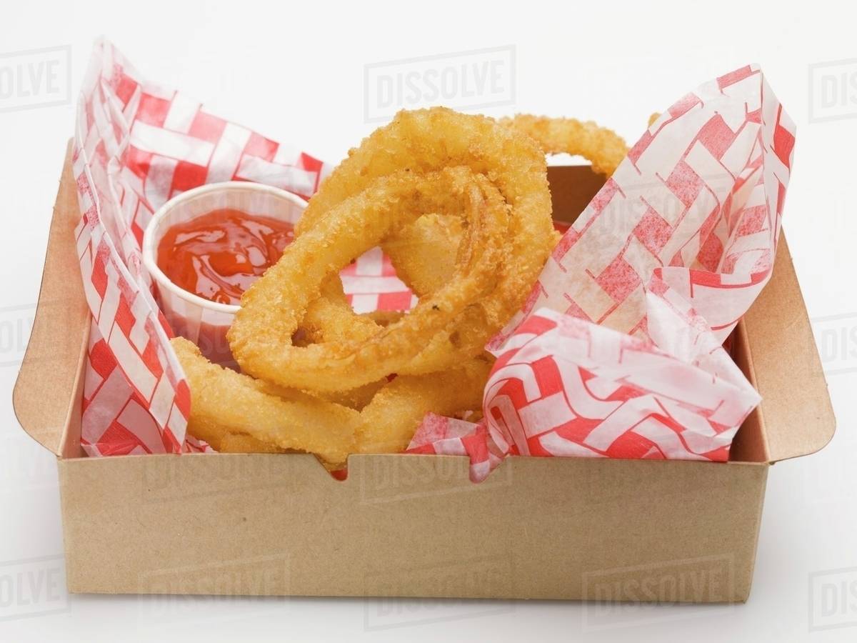 Deep-fried onion rings with ketchup in a cardboard box - Royalty-free ...