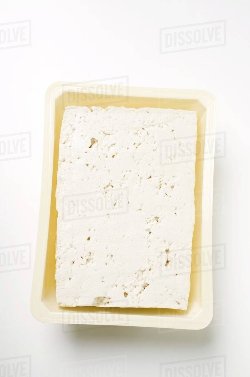 Tofu in plastic container (overhead view) - Stock Photo - Dissolve